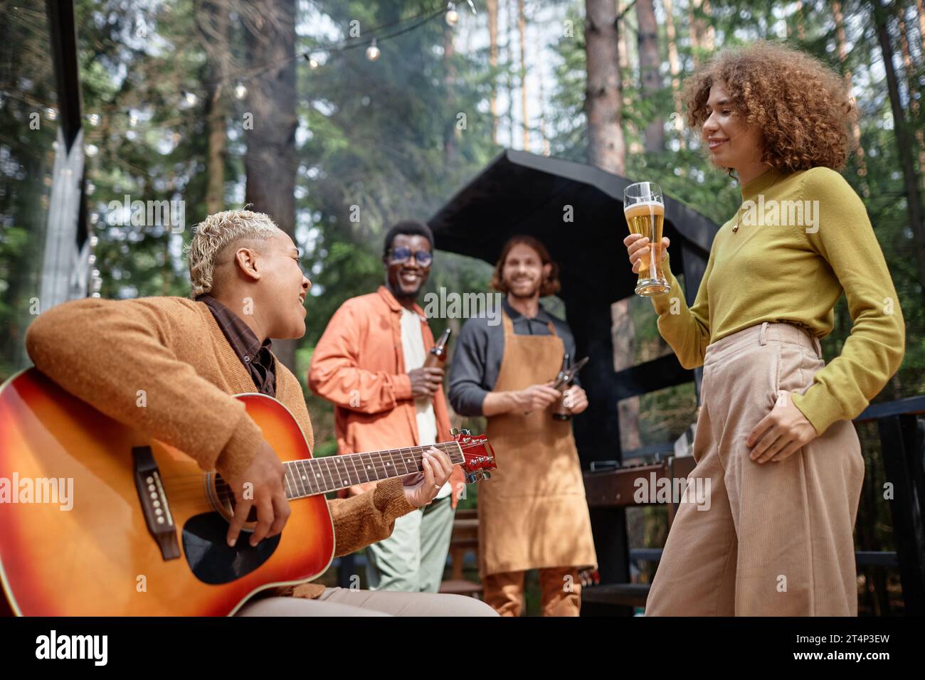 Group of young friends playing guitar and singing songs at picnic ...