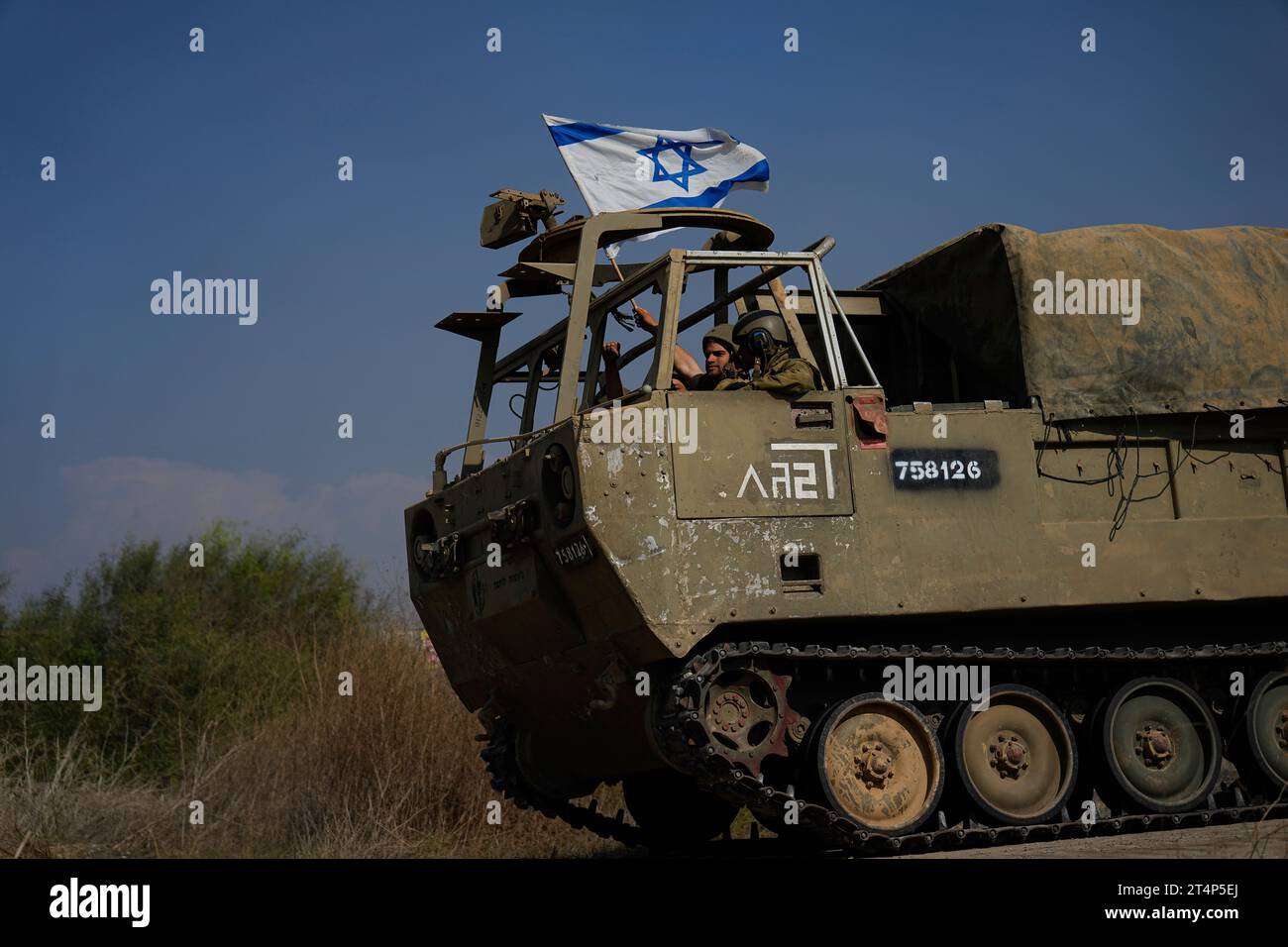 Israeli soldiers wave their national flag as they move towards the Gaza ...