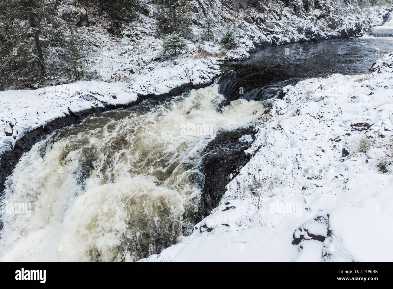 Snowy cascade waterfall landscape. Kivach Falls on a cold cloudy winter ...