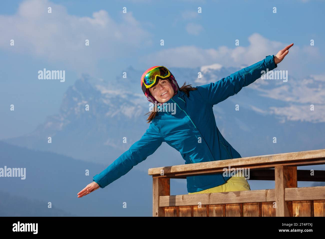 Happy skier stretching arms posing on balcony over mountain Stock Photo ...