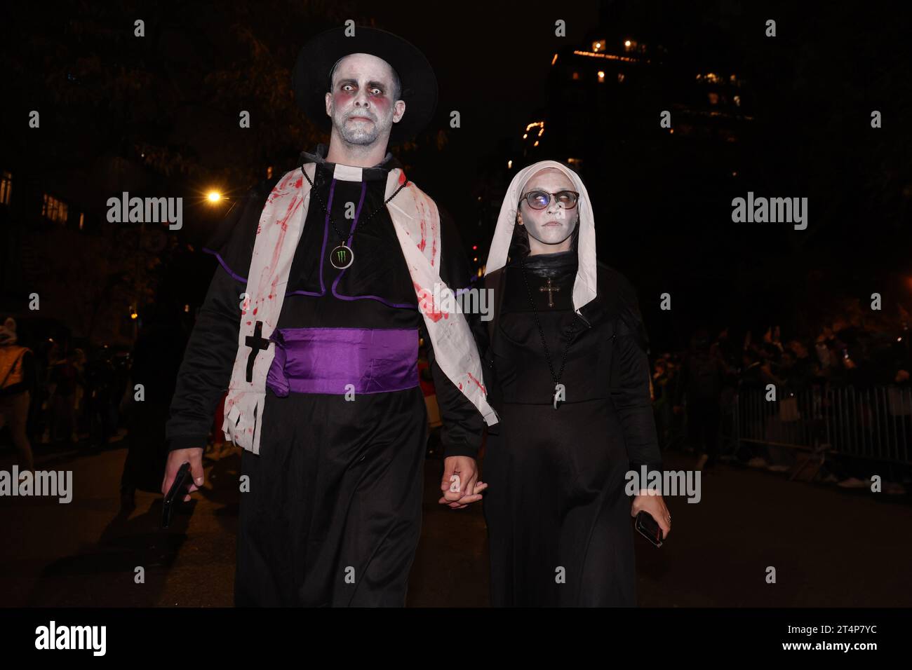 Revelers dressed as ghoulish looking priest and a nun attend the New ...