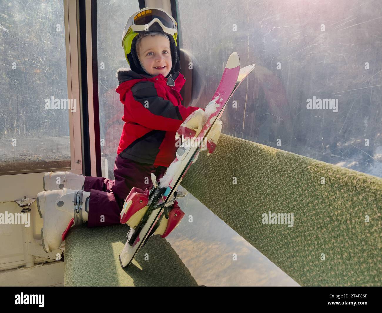 Smiling small skier lifting up in cable car ready to ride Stock Photo ...