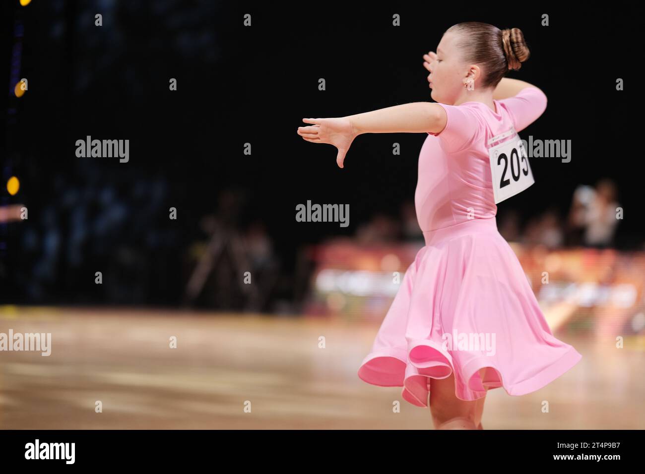Behind the dancer - a girl dancer-athlete in a pale pink dress against ...