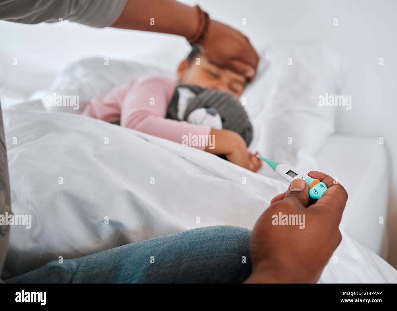 Whats her temperature. an unrecognizable parent checking a sick boys ...