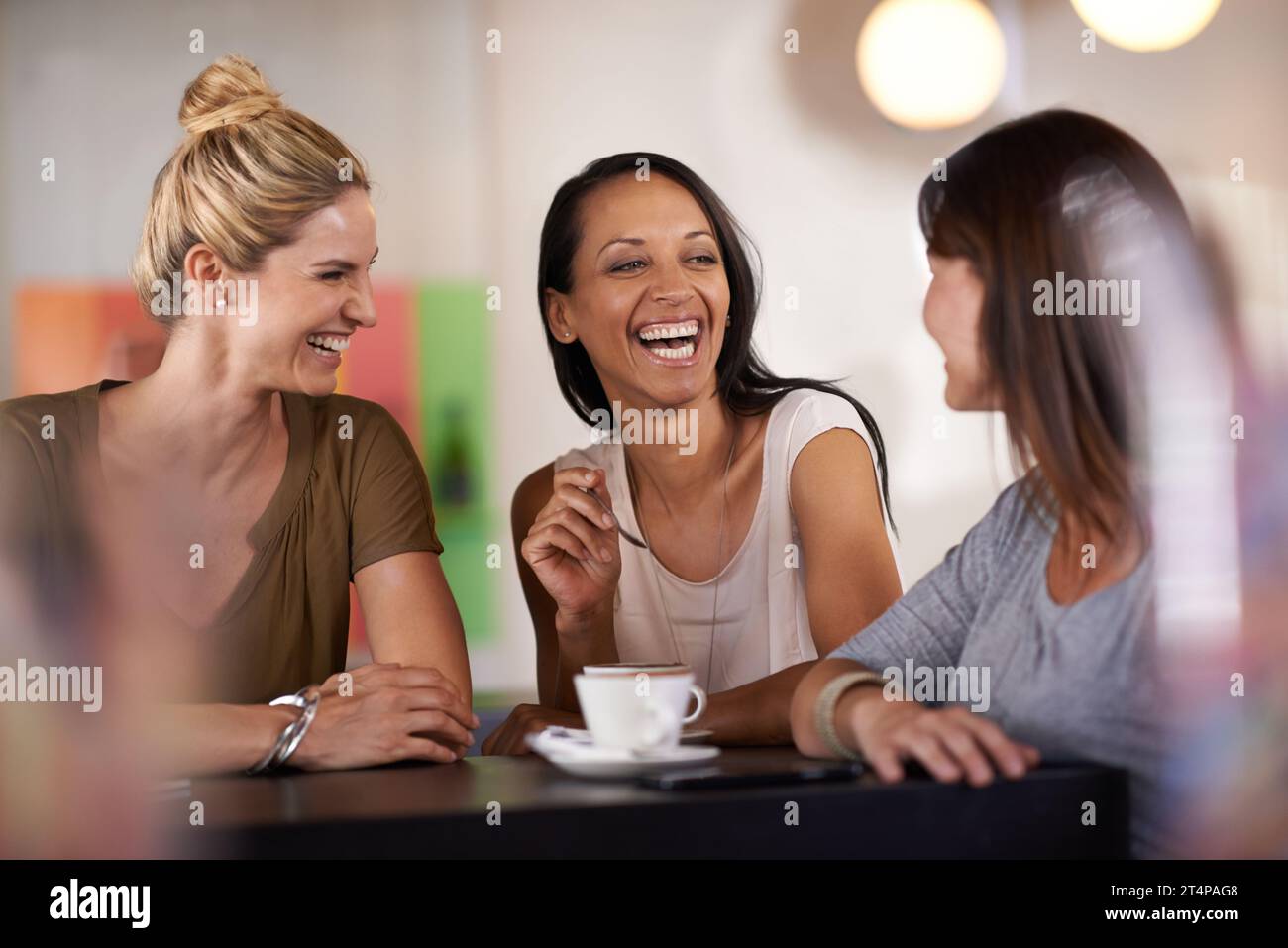 Once she got them laughing they couldnt stop. three women enjoying a conversation in a ...