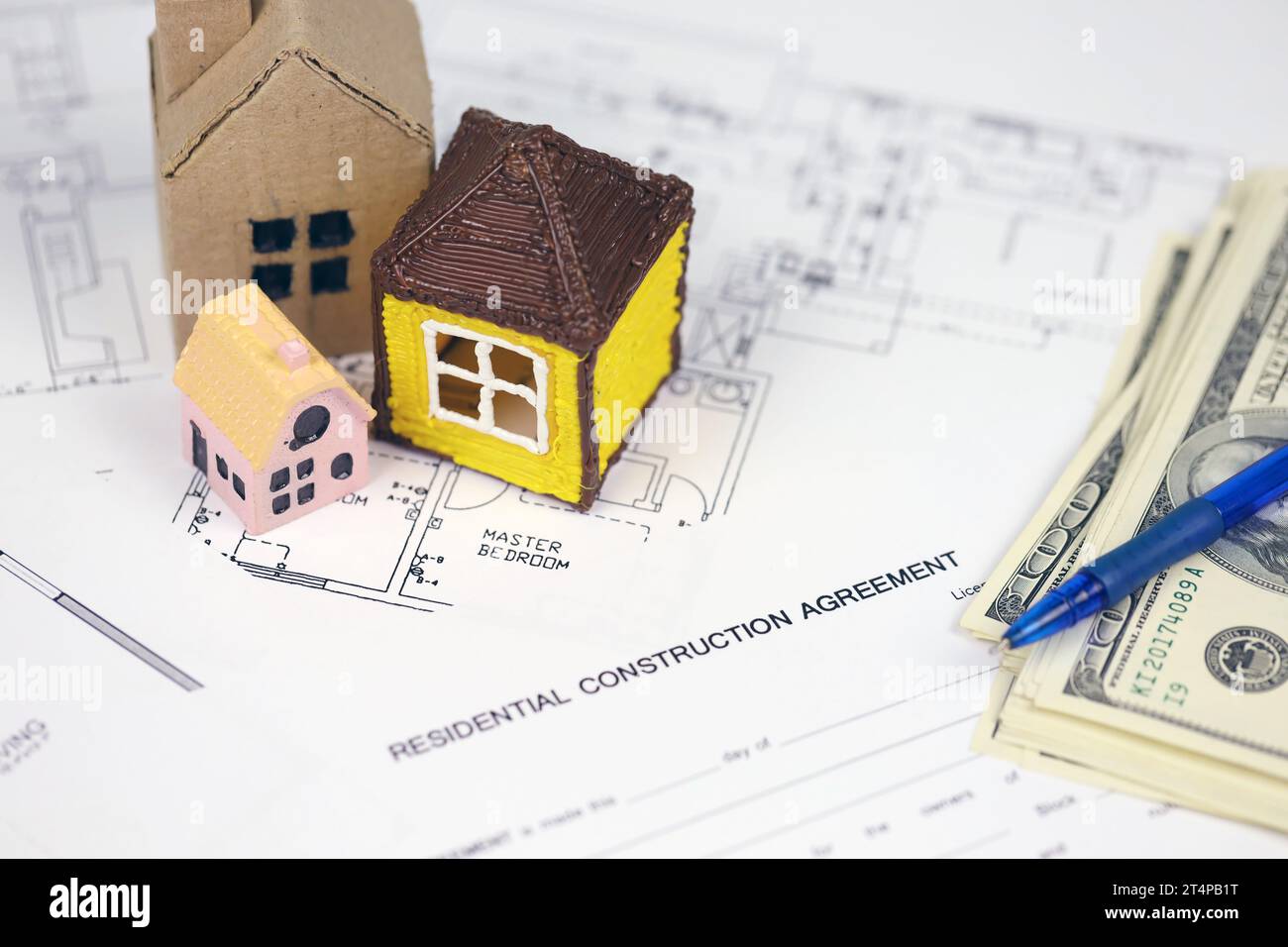 Residential construction agreement ready to sign with small toy houses ...