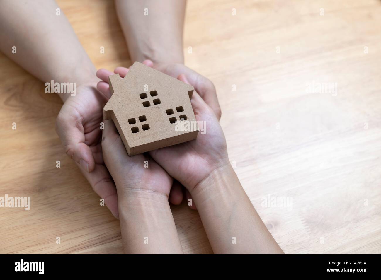 hands holding wooden house, family home, homeless housing crisis ...