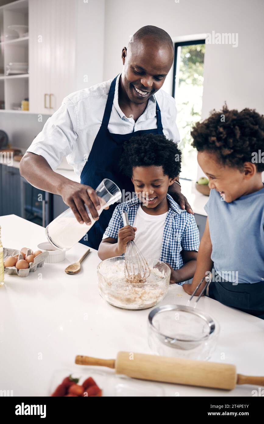 Adorable African American little boy with afro baking in the kitchen at ...