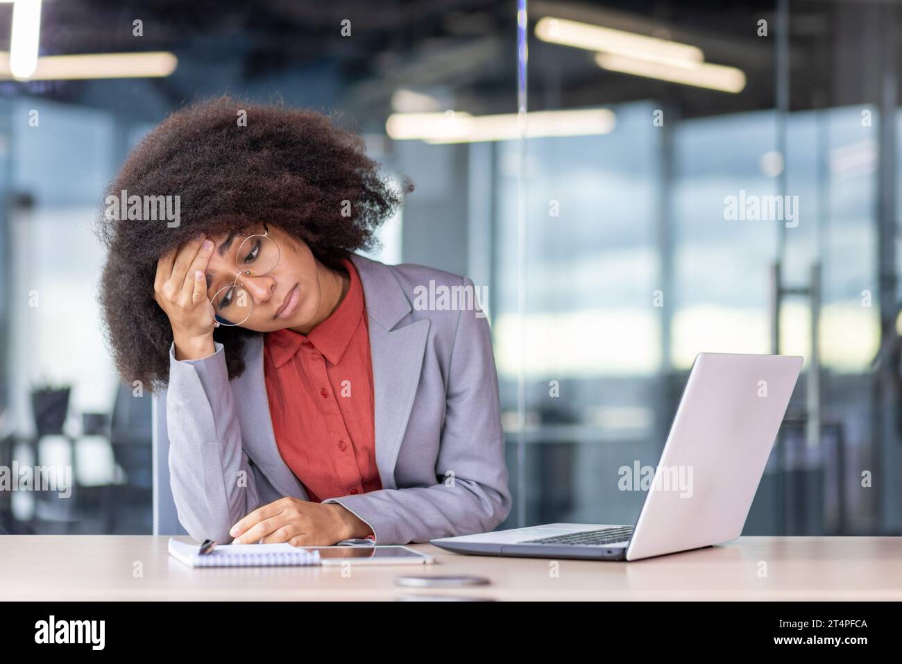 Frustrated and tired depressed business woman sitting at workplace ...