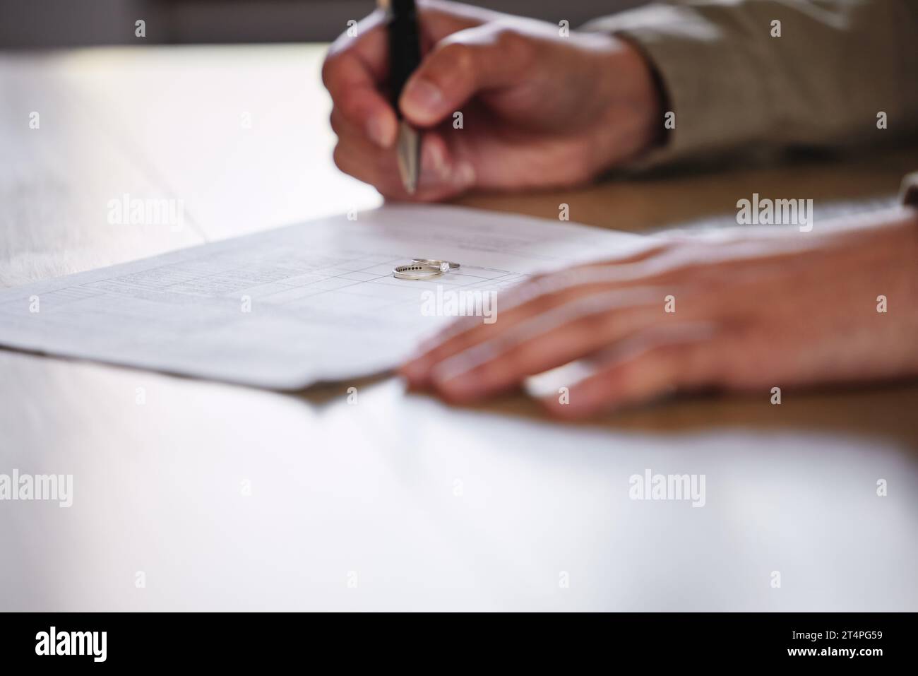Signing on the dotted line of heartbreak. a man signing divorce papers ...