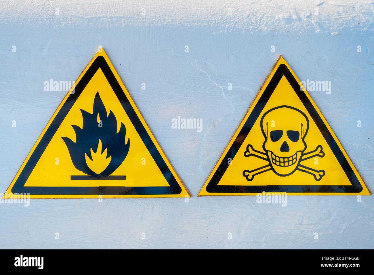 Danger warning signs. Two yellow triangles. Skull and bones. Fire ...