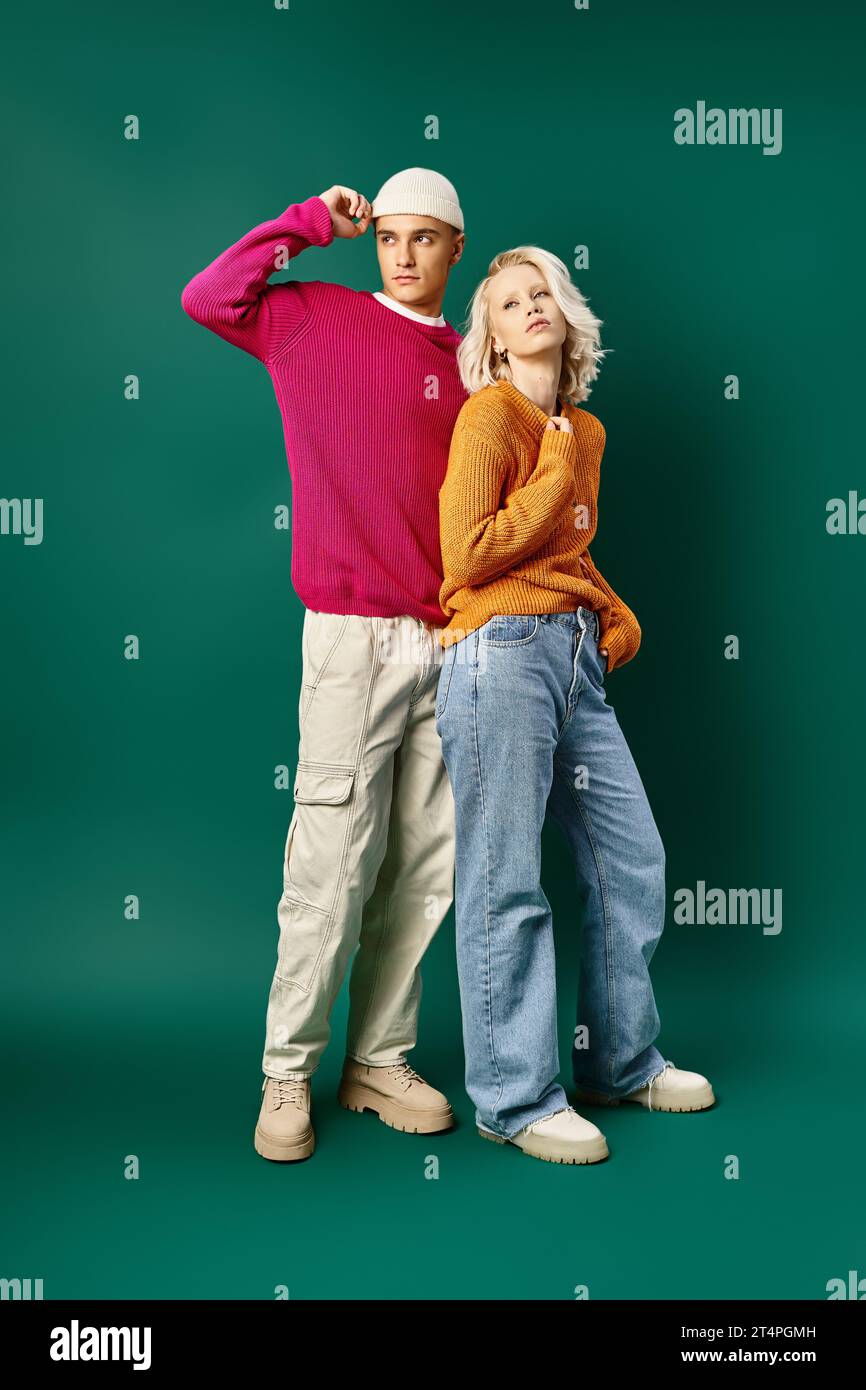 fashionable models in winter outfits posing together on turquoise ...