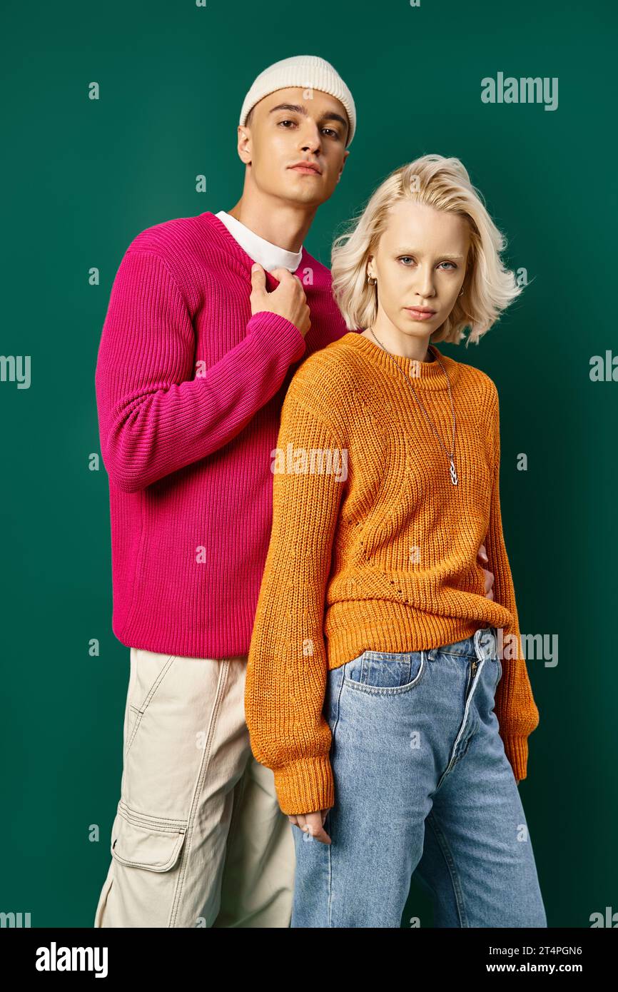 stylish young models in winter sweaters posing and looking at camera on ...