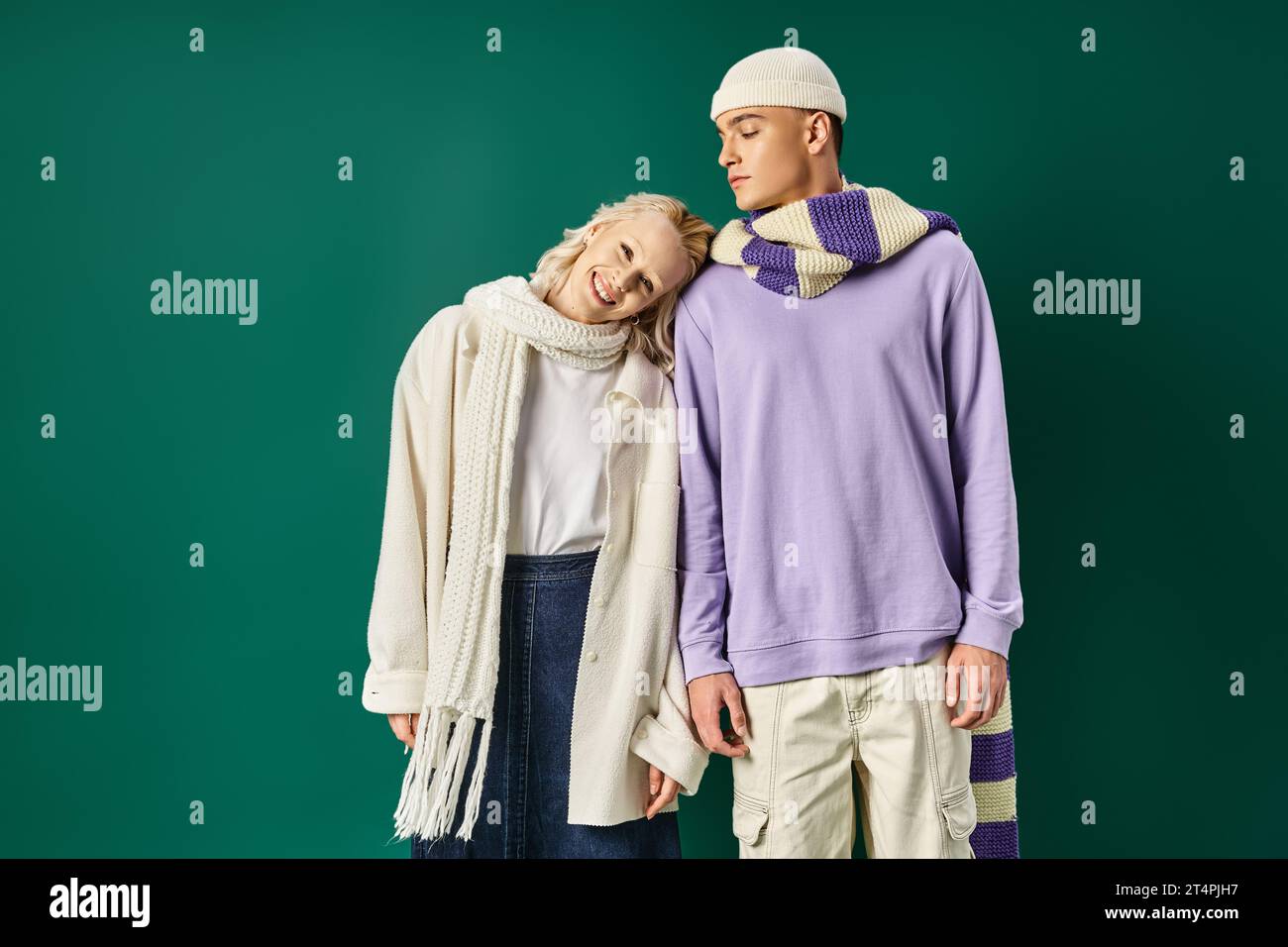 happy woman in stylish winter attire putting head on shoulder of tall ...