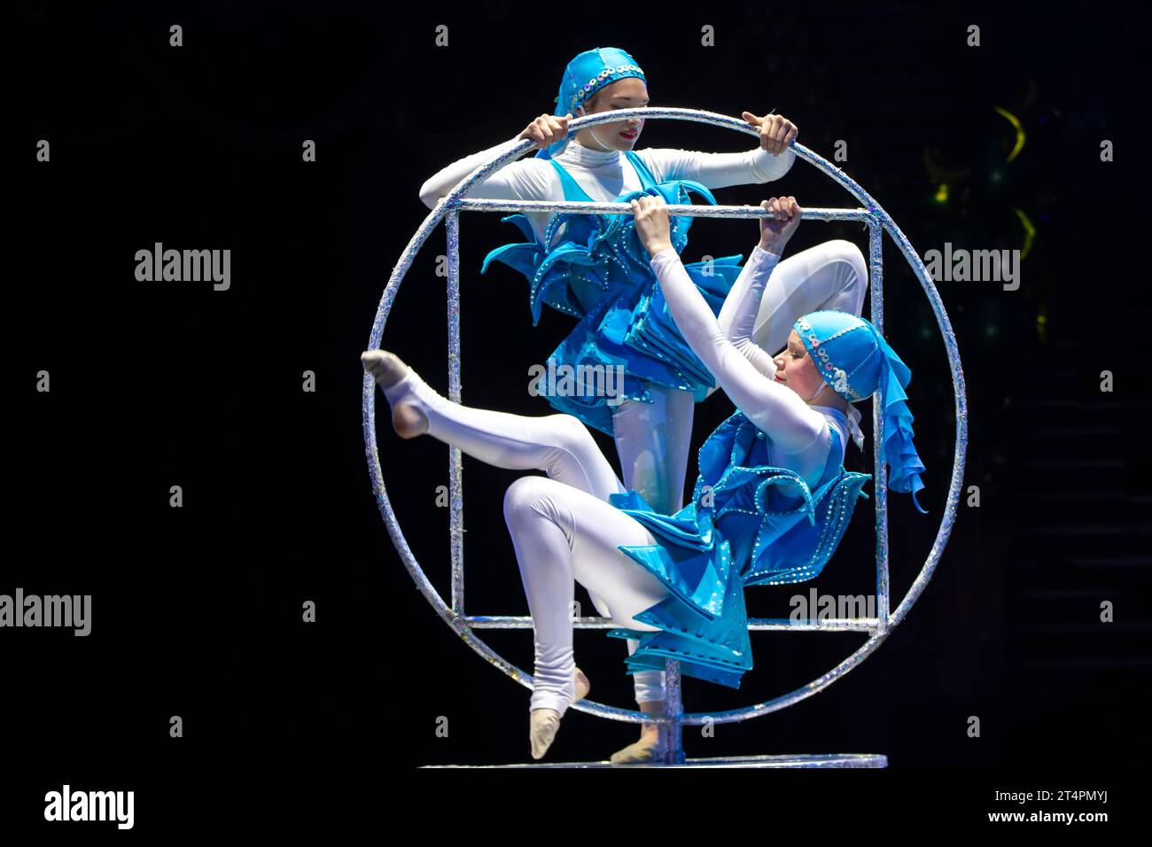 Two acrobat girls show a circus number on a dark background. Acrobatic performance Stock Photo ...