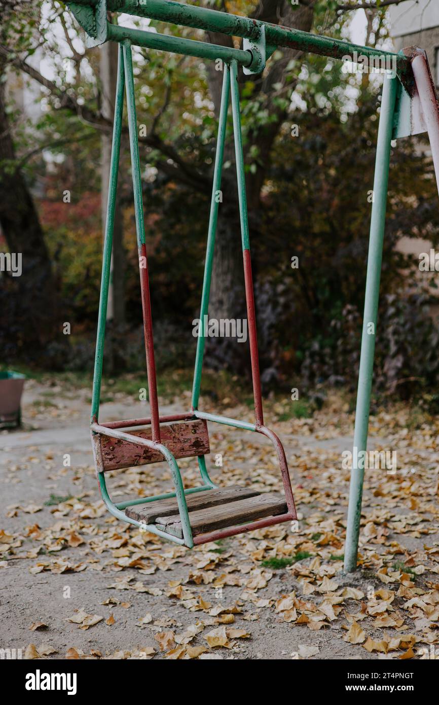Old swing on a children's playground made of metal structure. Outdated ...