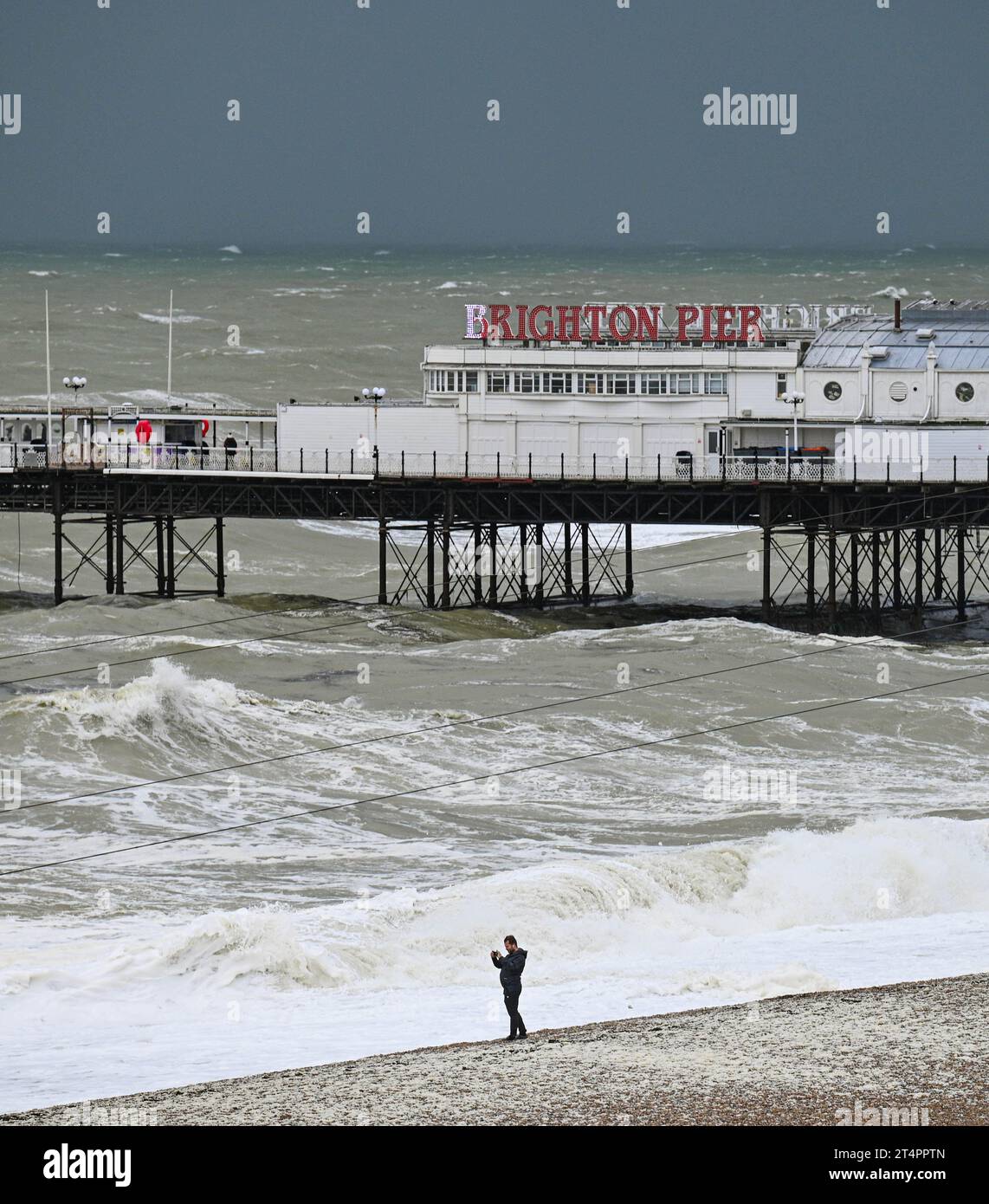 Brighton UK 1st November 2023 - Visitors watch waves crashing onto ...