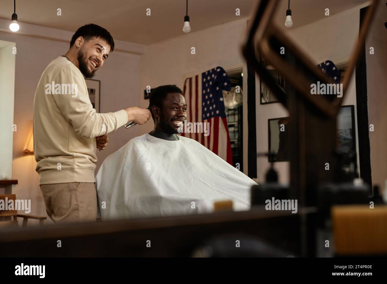 African American happy man cutting his hair in barber shop Stock Photo ...