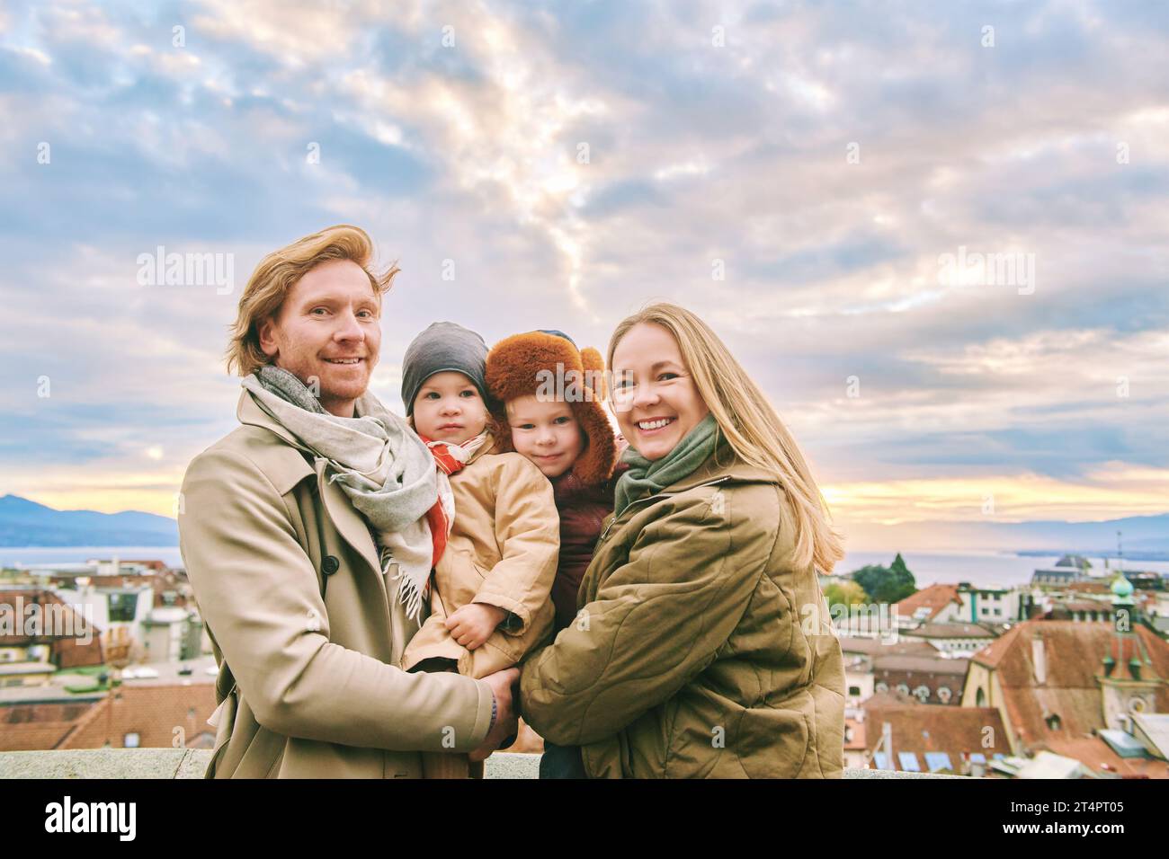 Outdoor portrait of happy family of four, young couple with two little ...
