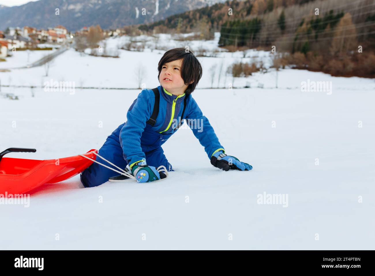 girl with short dark hair in blue winter clothes going up the snowy ...