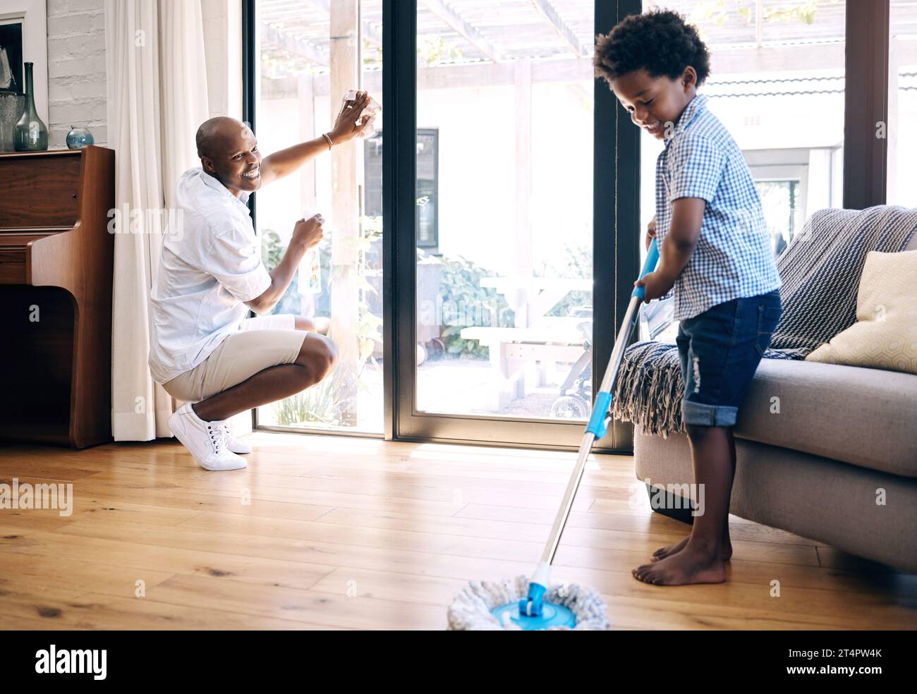 Mature african american dad and his young little son doing housework in ...