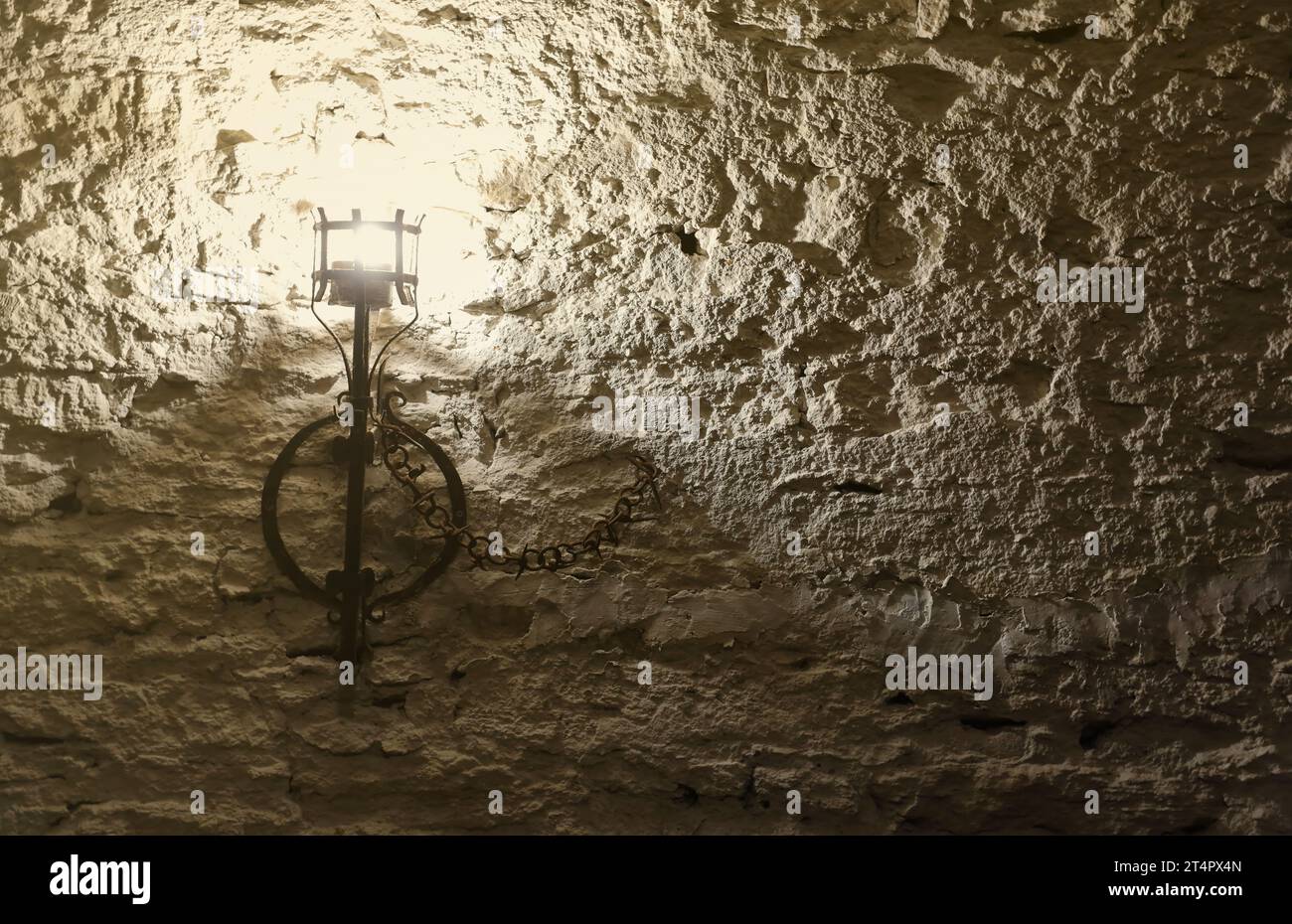 Lighted medieval castle torch hanging on a stone wall, vintage objects ...