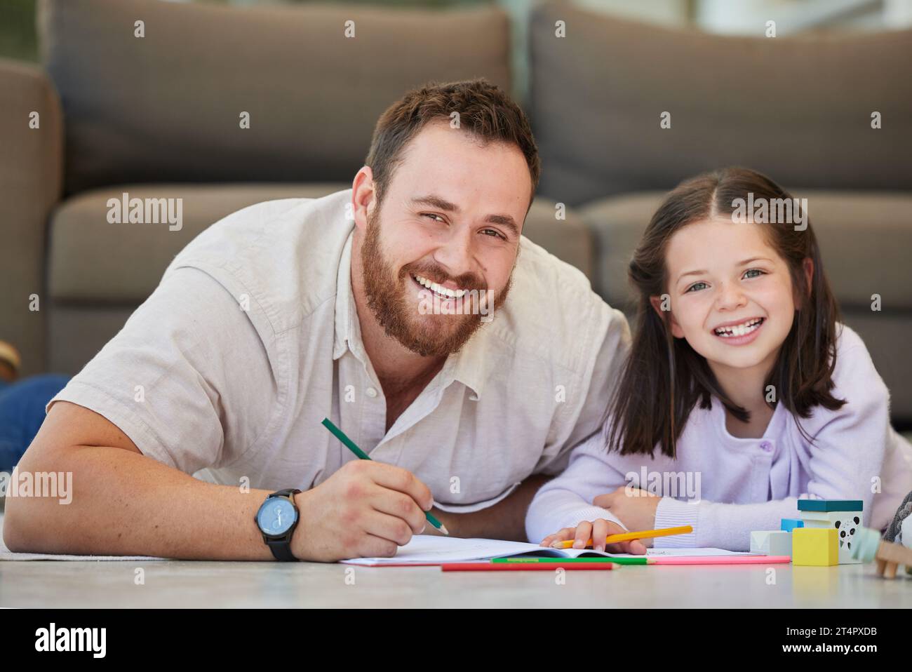 Father and daughter doing homework together drawing pictures and having fun. Dad teaching ...