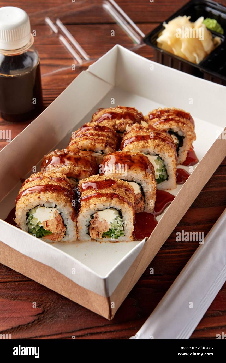 Japanese takeaway meal at home table, sushi rolls with soy sauce ...