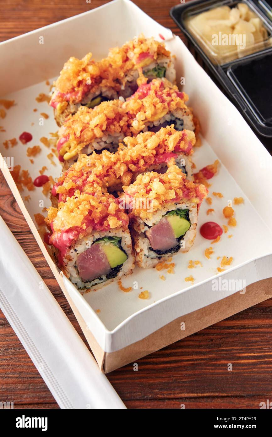 Japanese takeaway meal at home table, sushi rolls with soy sauce ...