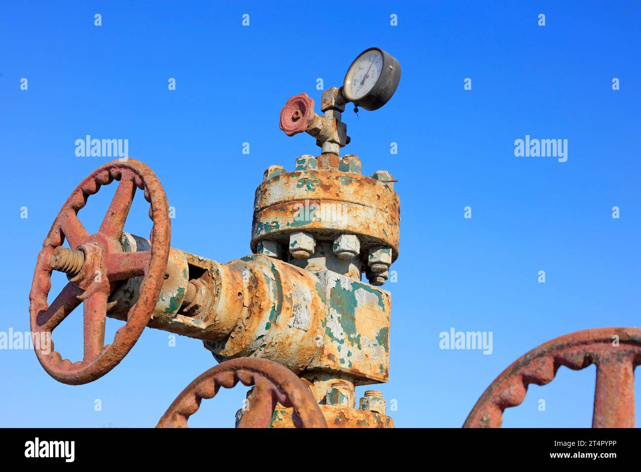 Oil pipeline control handwheel and pressure gage, closeup of photo ...