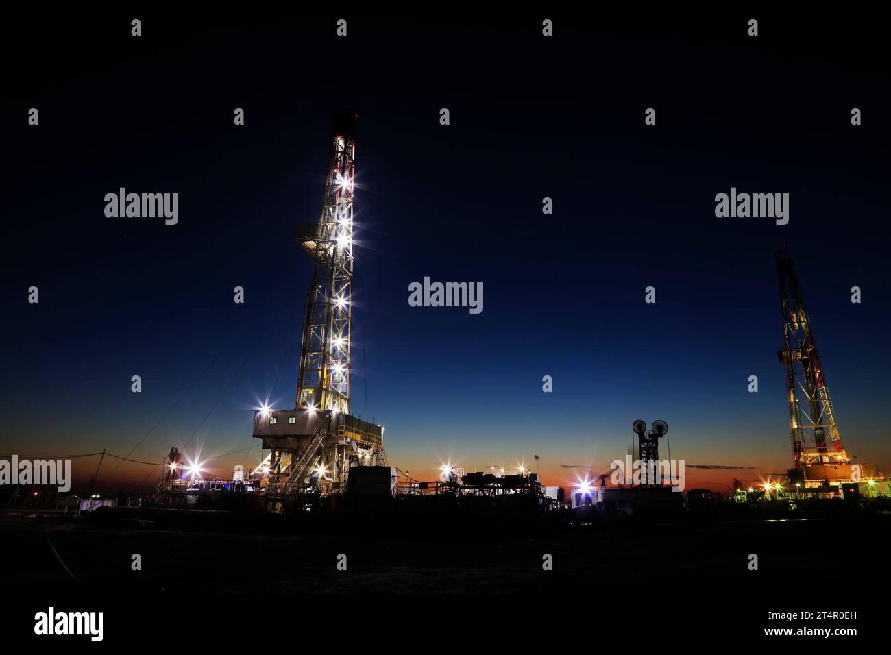 Oil drilling derrick and lights in oilfield Stock Photo - Alamy
