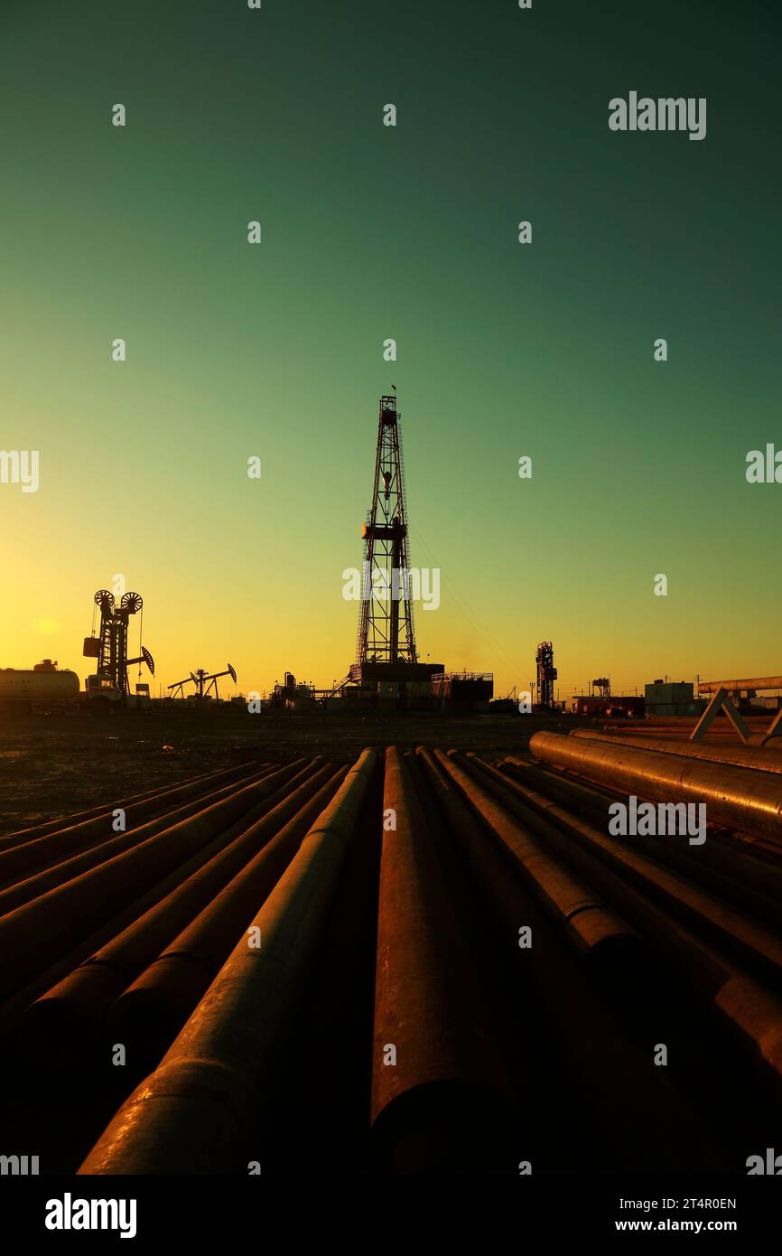 Oil drilling derrick and pipelines in oilfield Stock Photo - Alamy