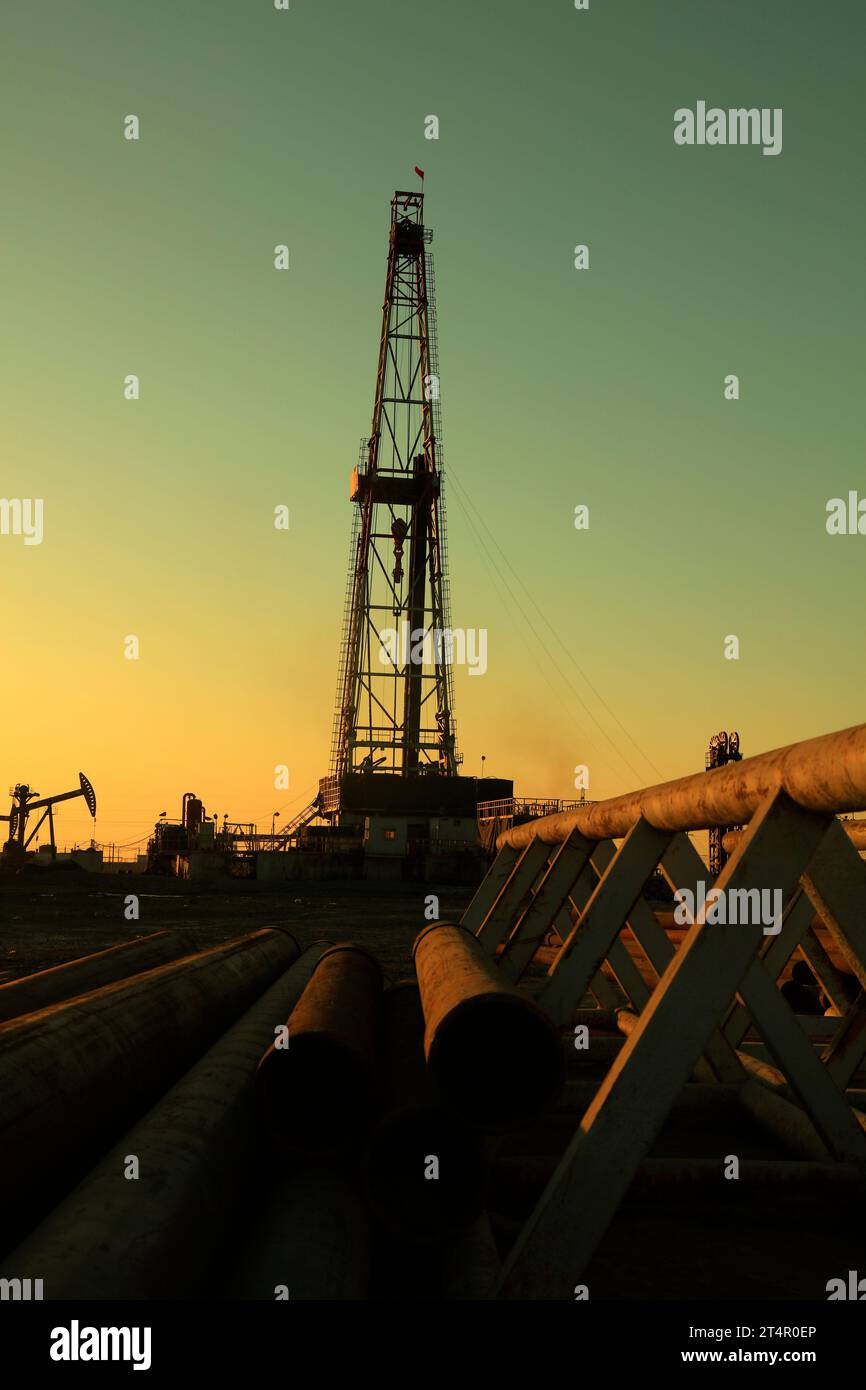 Oil drilling derrick and pipelines in oilfield Stock Photo - Alamy