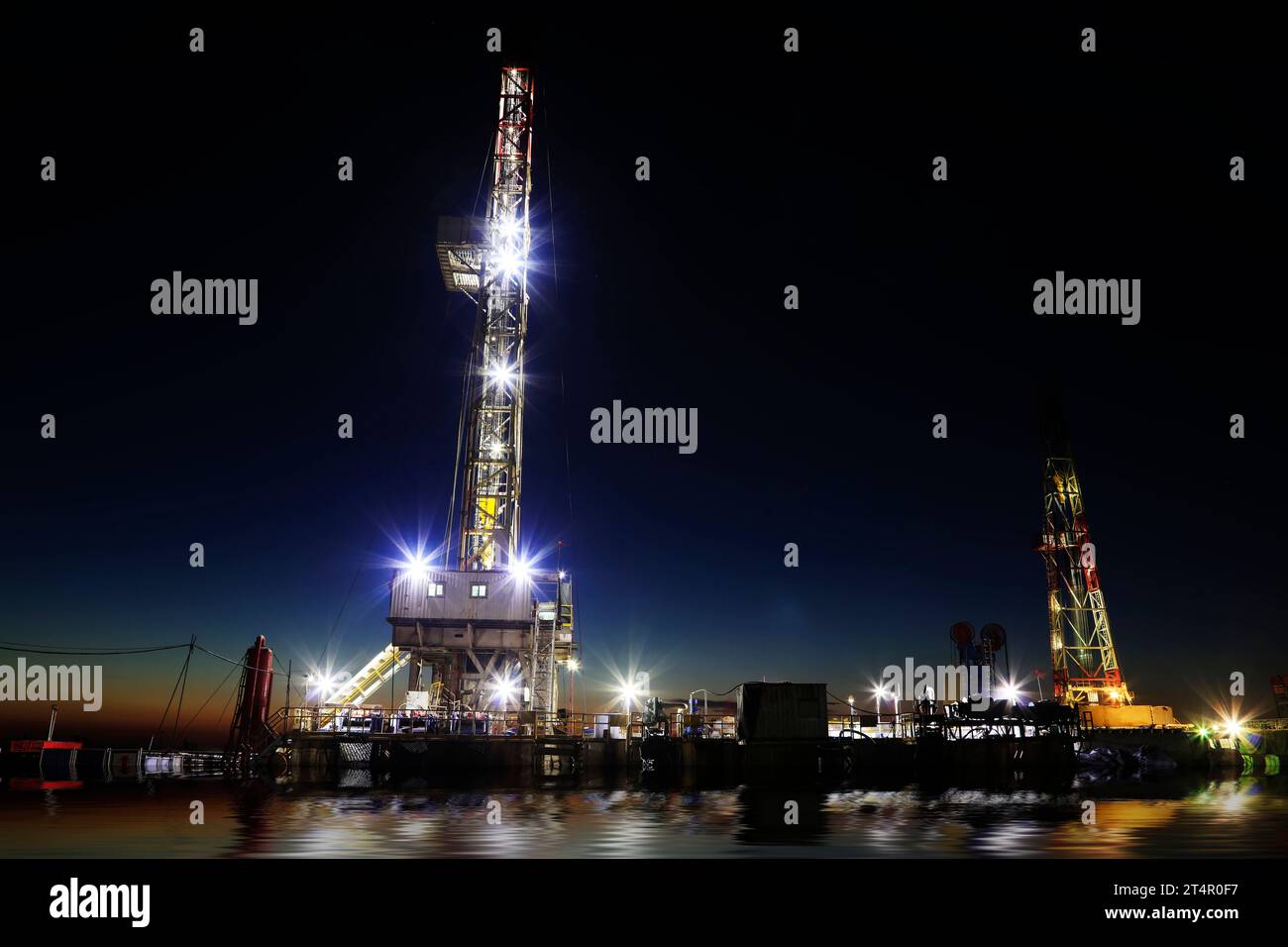 Oil drilling derrick and lights in oilfield Stock Photo - Alamy