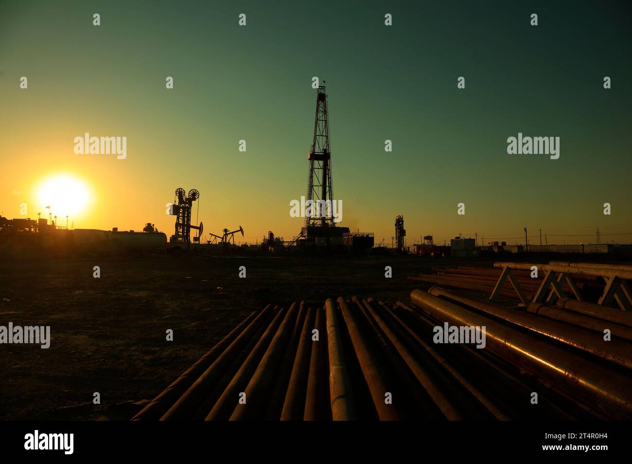 Oil drilling derrick and pipelines in oilfield Stock Photo - Alamy