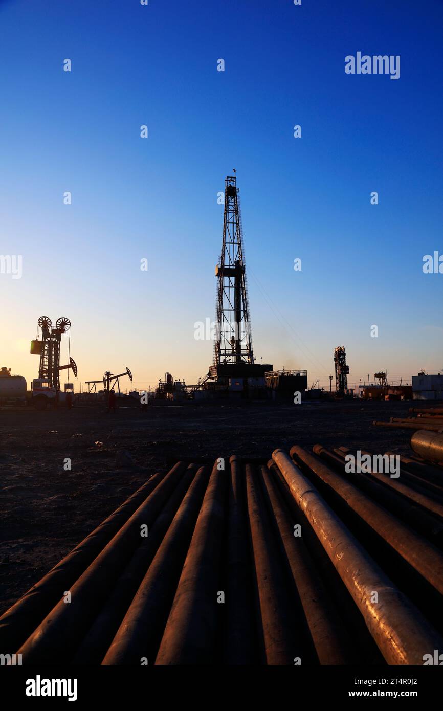Oil drilling derrick and pipelines in oilfield Stock Photo - Alamy