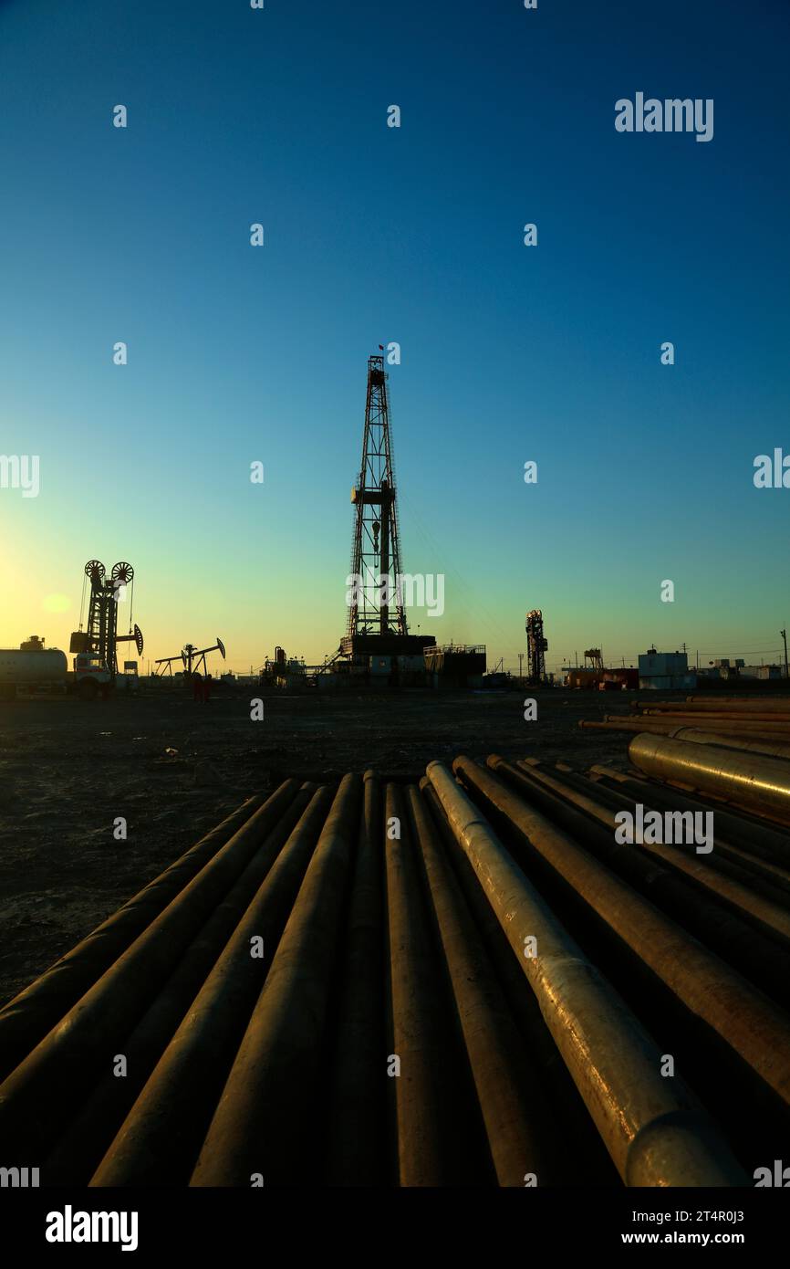 Oil drilling derrick and pipelines in oilfield Stock Photo - Alamy