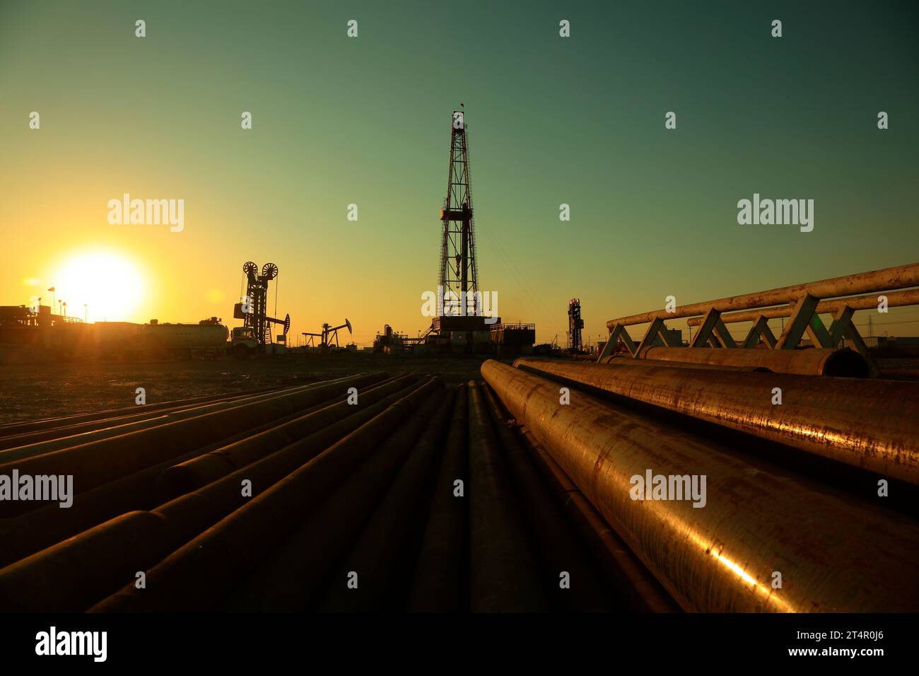 Oil drilling derrick and pipelines in oilfield Stock Photo - Alamy