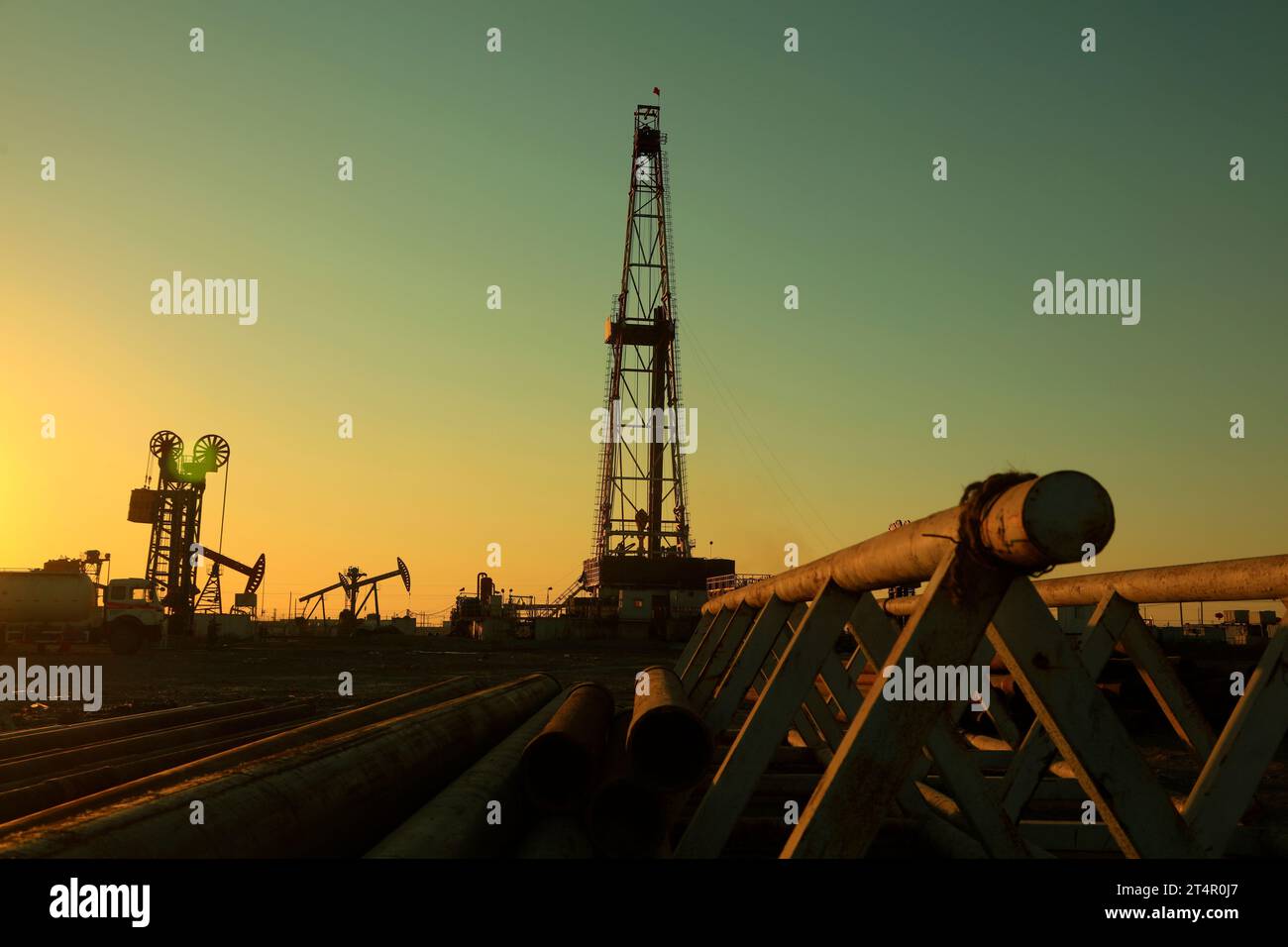 Oil drilling derrick and pipelines in oilfield Stock Photo - Alamy