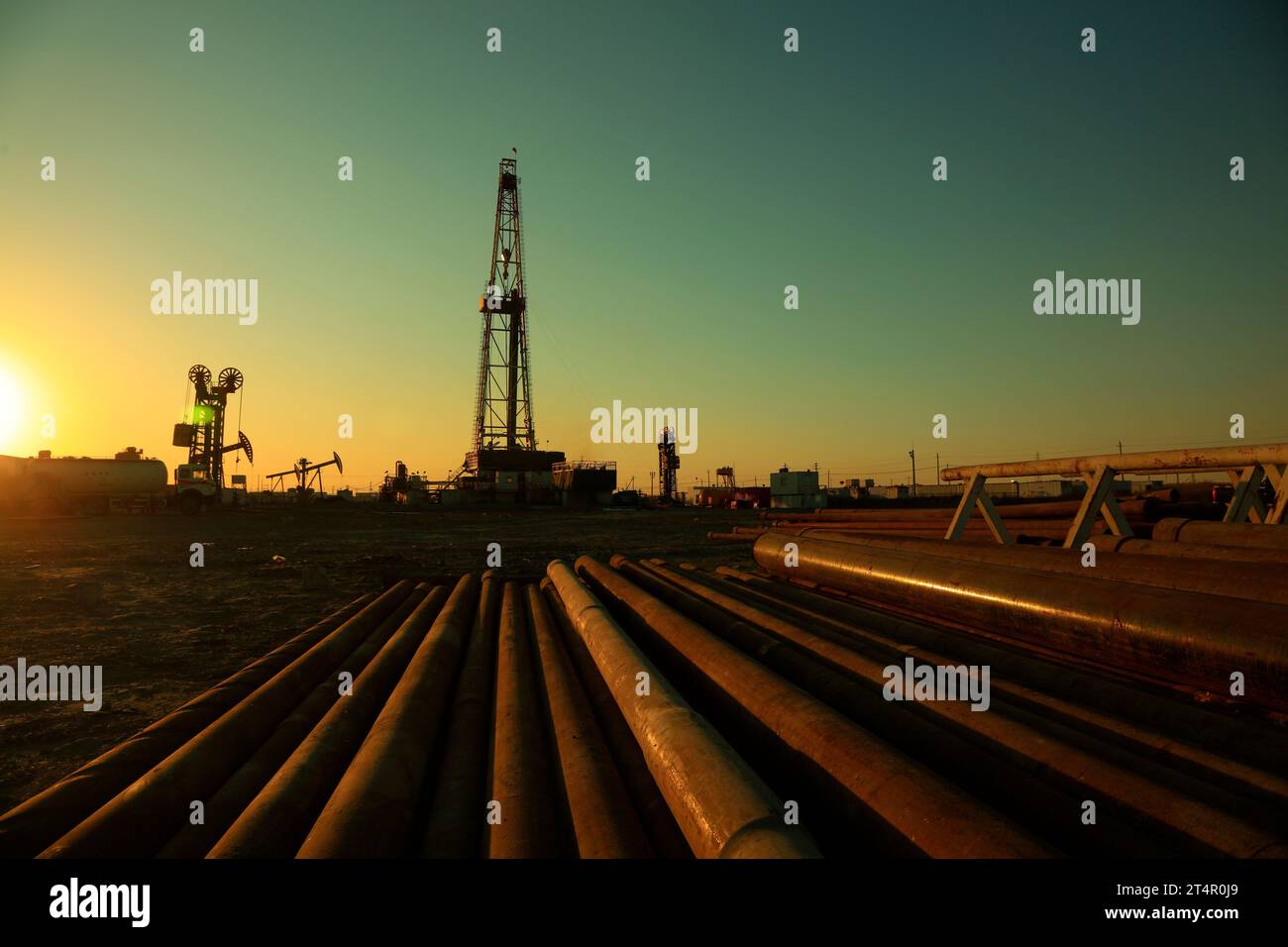Oil drilling derrick and pipelines in oilfield Stock Photo - Alamy