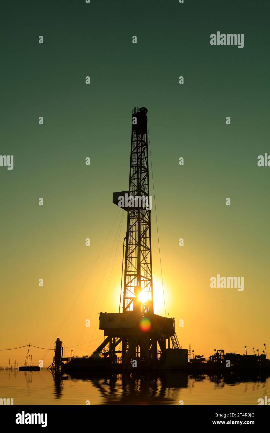 Oil drilling derrick in the sunset Stock Photo - Alamy