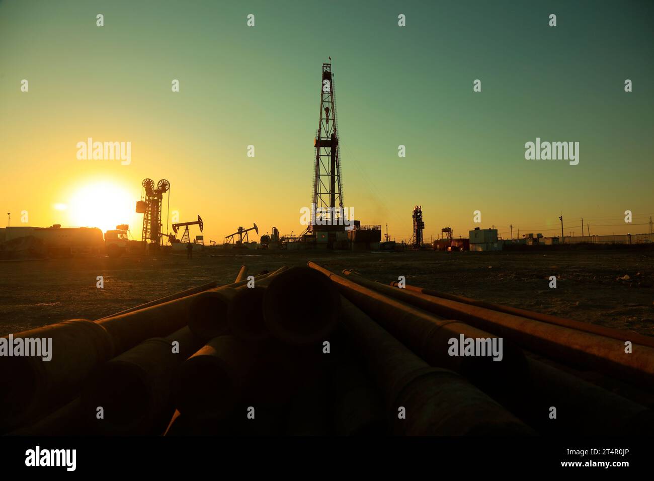 Oil drilling derrick and pipelines in oilfield Stock Photo - Alamy