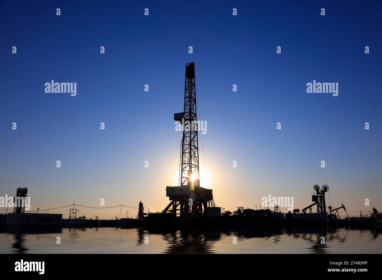 Oil drilling derrick in the sunset Stock Photo - Alamy