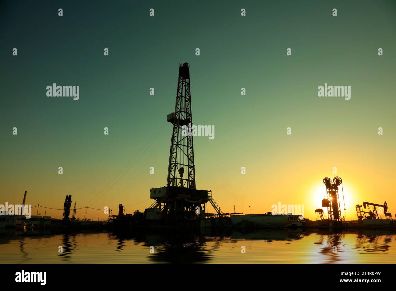 Oil drilling derrick in the sunset Stock Photo - Alamy