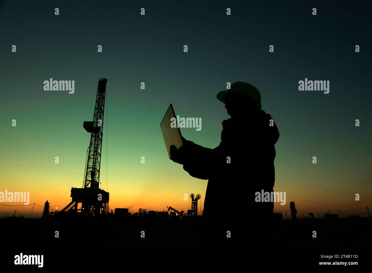 Oil drilling frame and exploration technician in a oilfield Stock Photo ...
