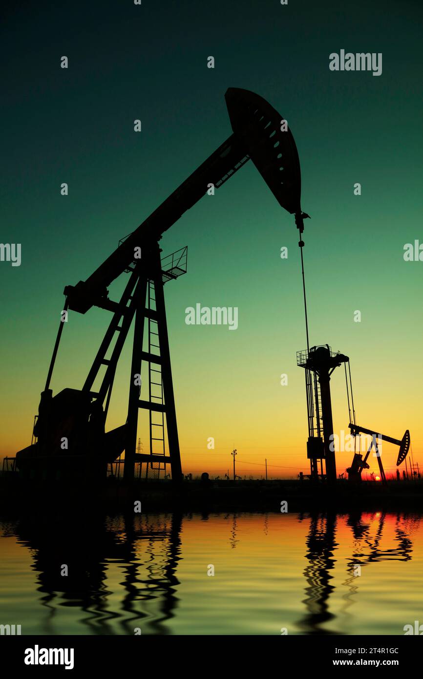 Beam balanced pumping unit under the setting sun in oilfield Stock ...
