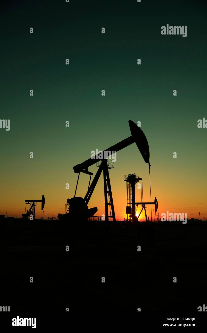 Beam balanced pumping unit under the setting sun in oilfield Stock ...