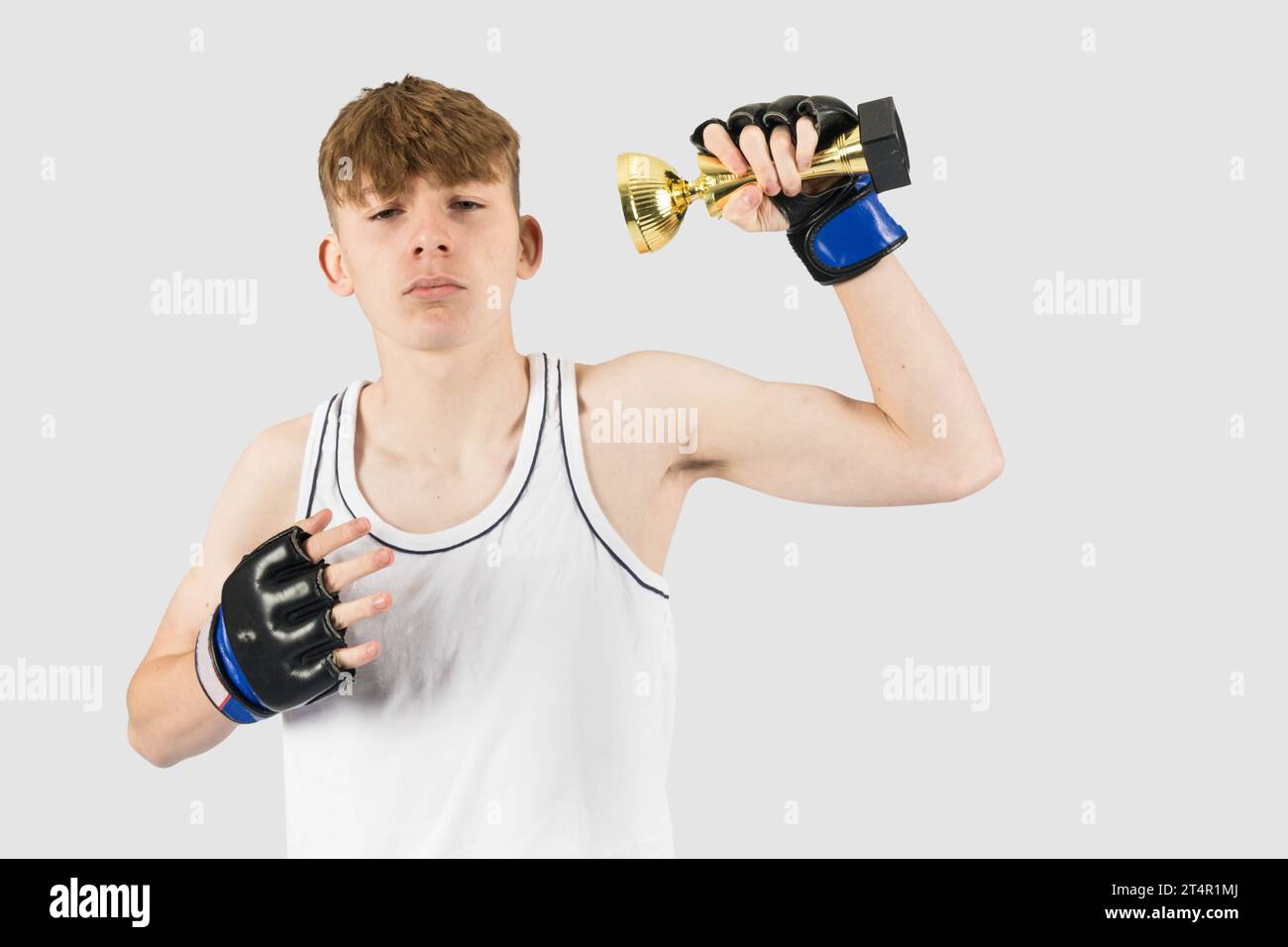 A caucasian teenage boy wearing MMA style boxing gloves celebrating ...