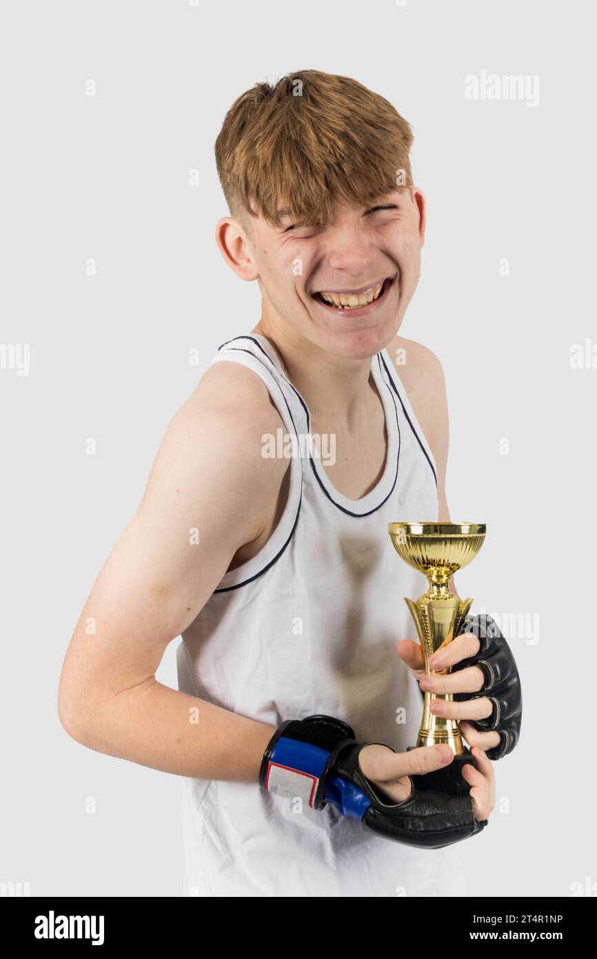 A caucasian teenage boy wearing MMA style boxing gloves celebrating ...
