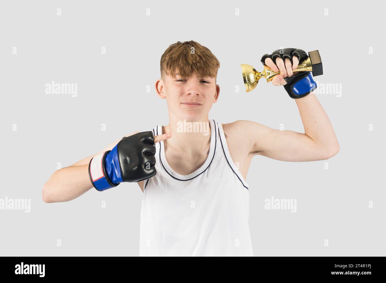 A caucasian teenage boy wearing MMA style boxing gloves celebrating ...